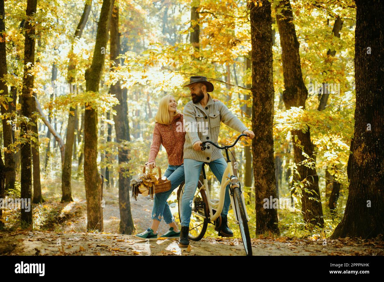Couple in love ride bicycle together in forest park. Romantic date with ...