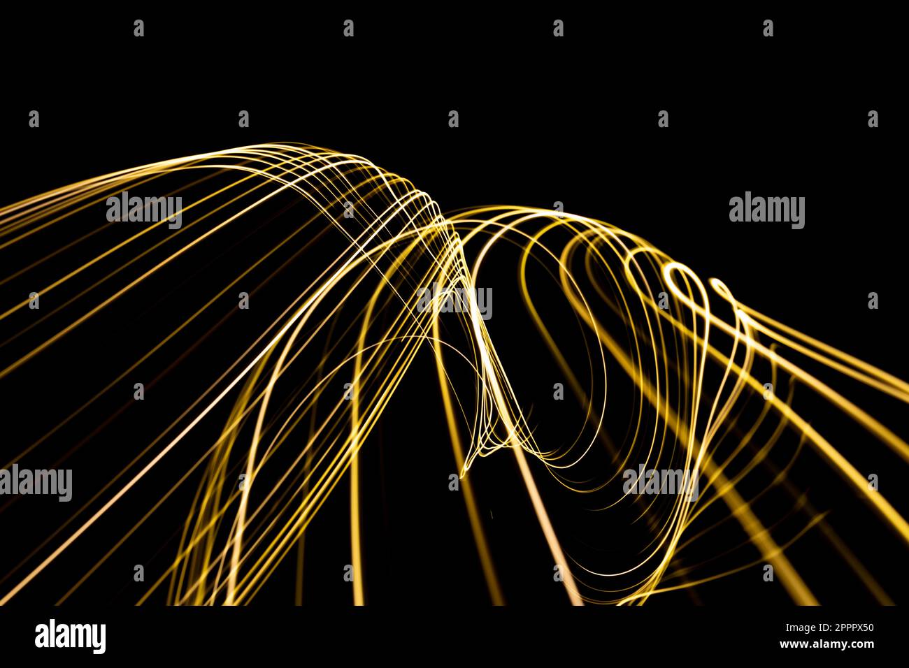 Abstract lights of golden colors forming patterns of curved lines ...