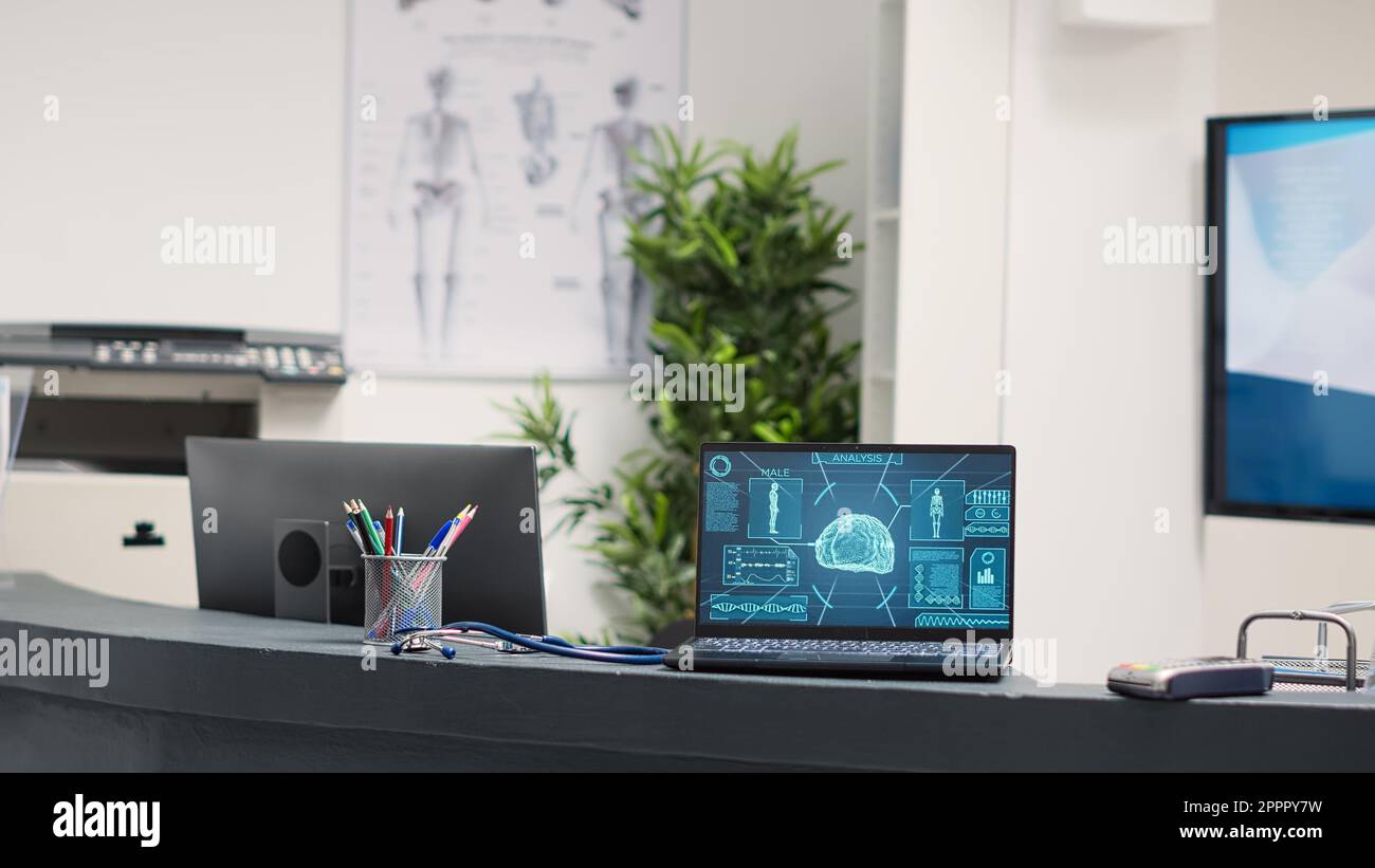 Laptop showing tomography scan at desk, empty hospital reception ...