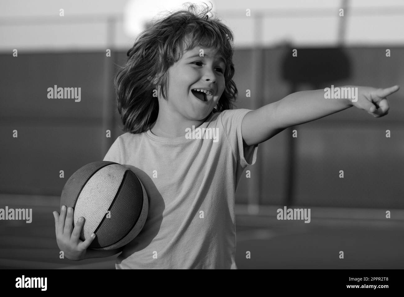 Happy smilin kid playing basketball, pointing showing gesture. Activity ...