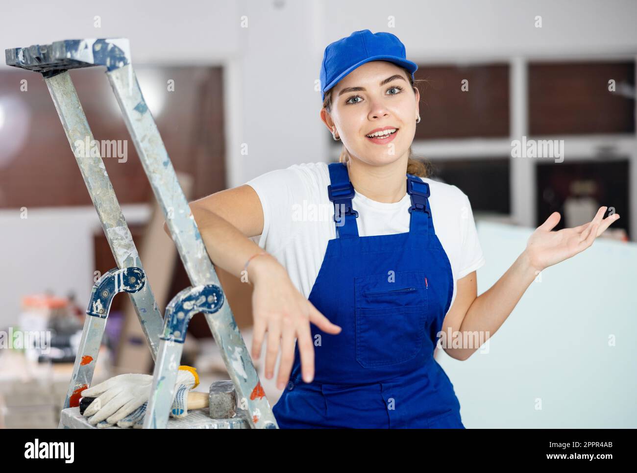 Woman foreman shows with her hand at a job well done on the repair of ...