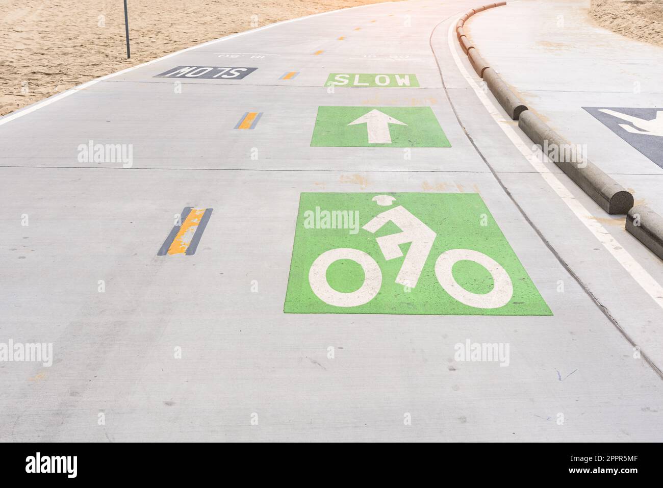 Curve along a paved bicycle lane on a sand beach Stock Photo - Alamy