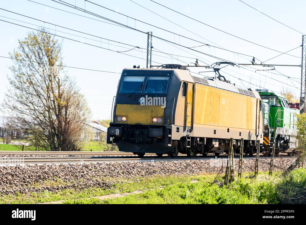 Powerful electric locomotive pulling a cargo train on a suny spring day ...