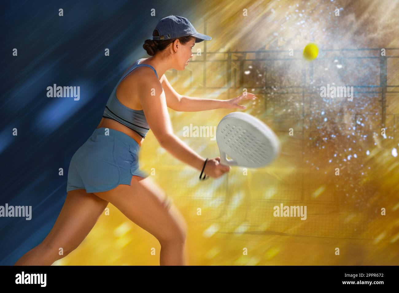 Determined sporty young woman doing her best playing padel in court ...