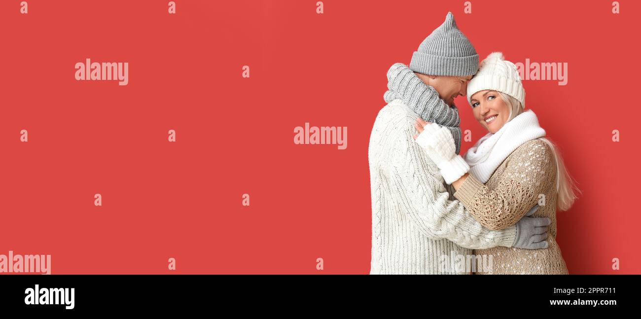 Portrait of happy mature couple on red background with space for text ...