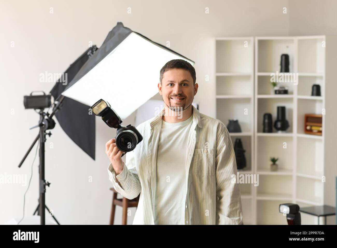 Handsome photographer with professional camera in studio Stock Photo ...