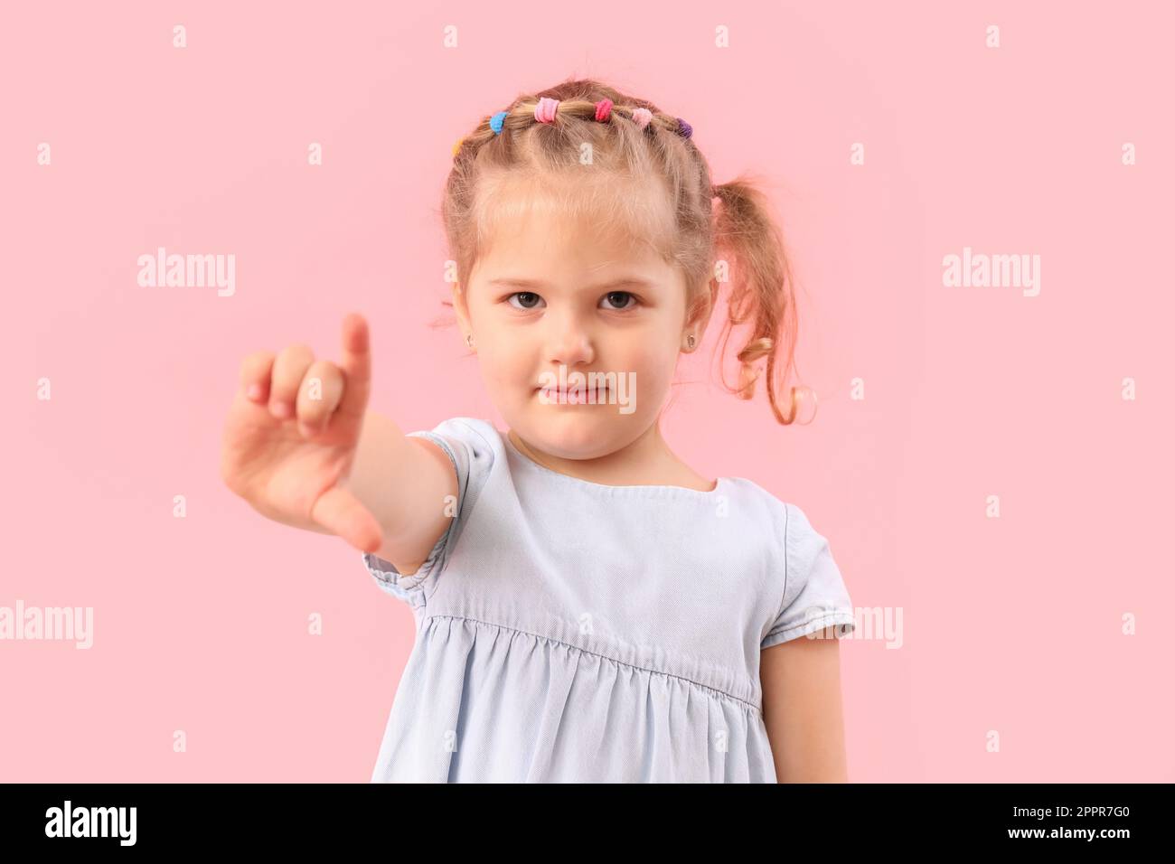Funny little girl showing loser gesture on pink background Stock Photo ...