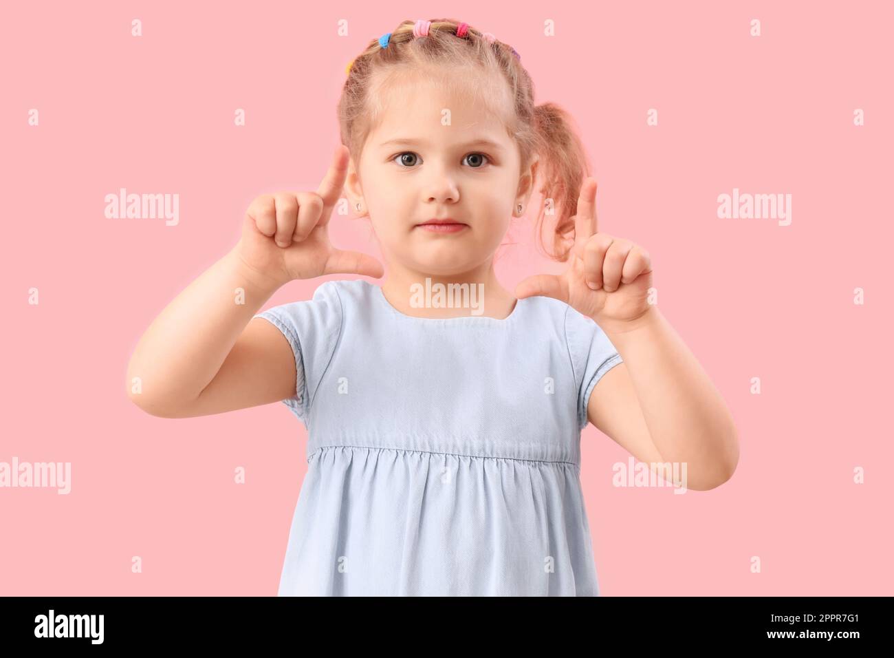 Funny little girl showing loser gesture on pink background Stock Photo ...