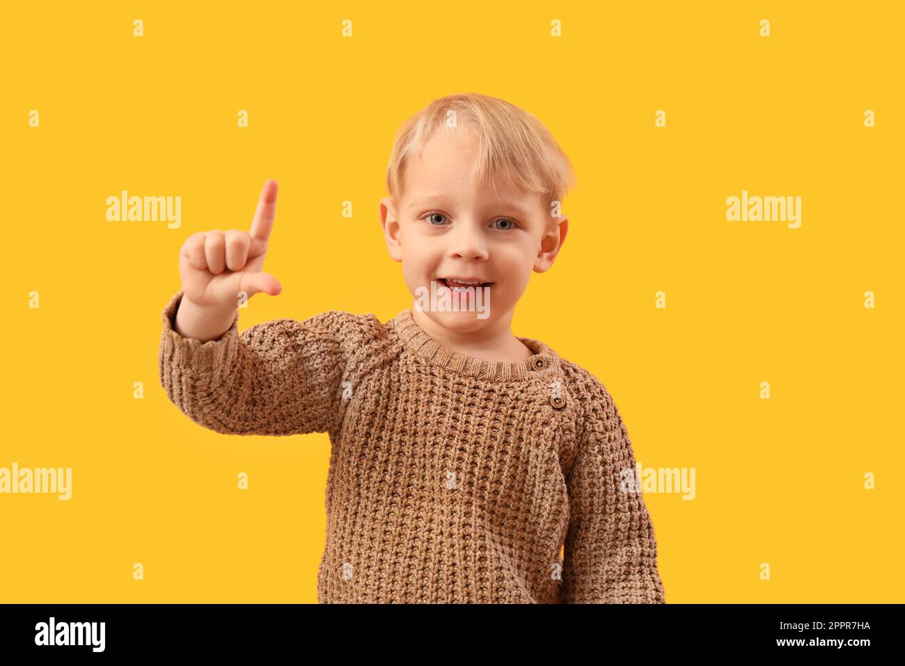 Funny little boy showing loser gesture on yellow background Stock Photo ...