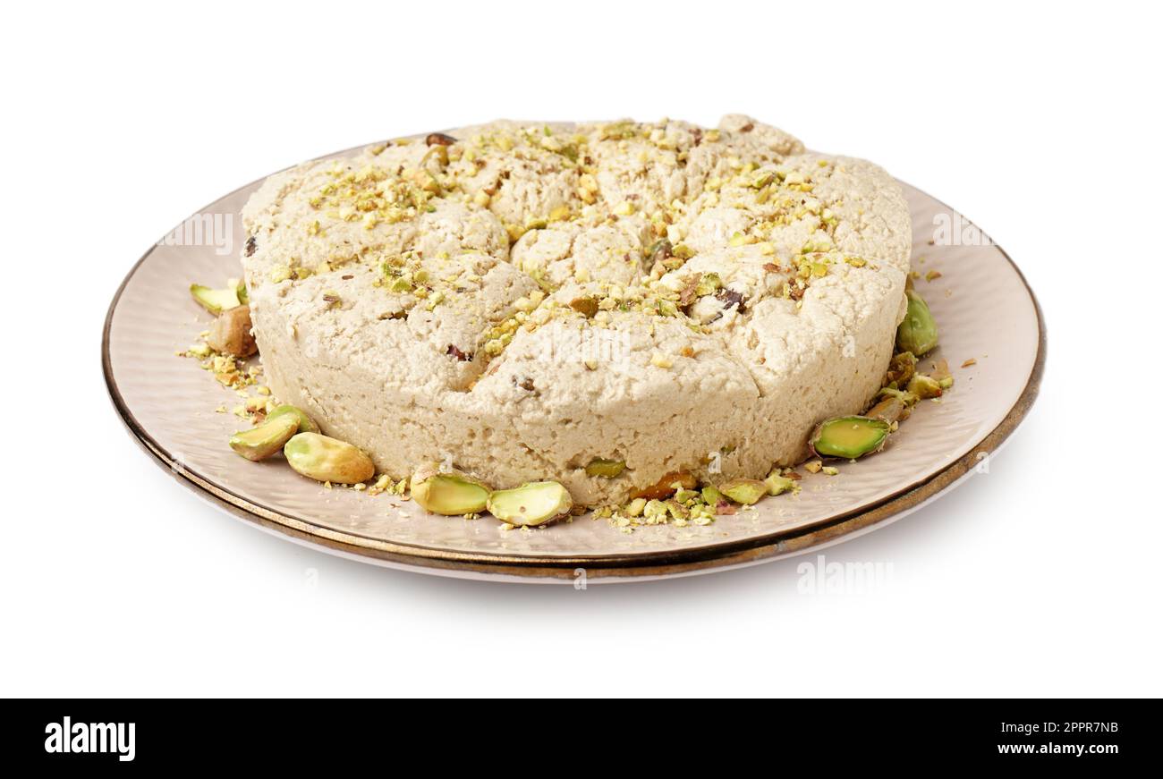 Plate of tasty Tahini halva with pistachios on white background Stock Photo - Alamy