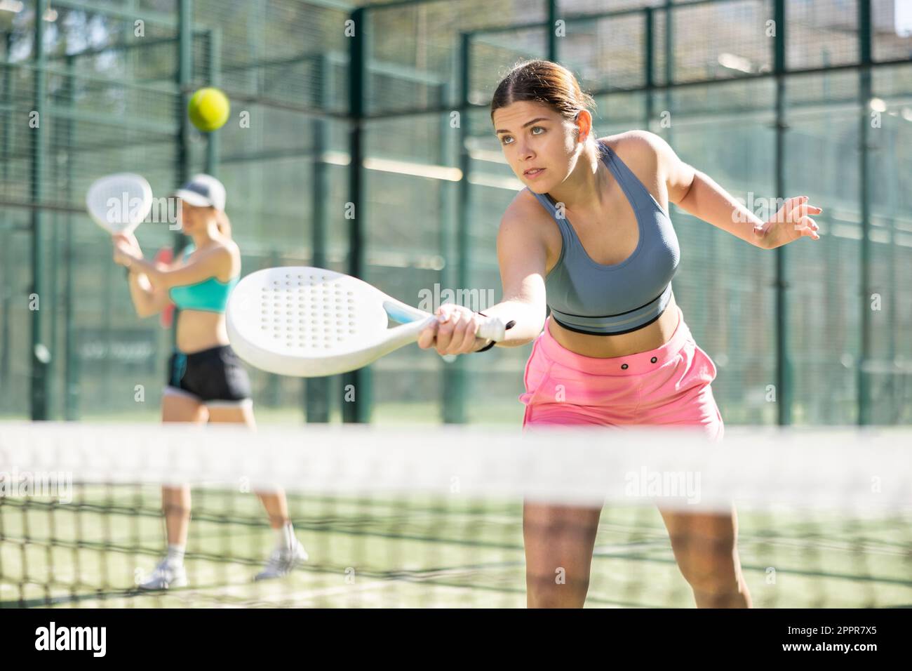 Young motivated woman playing padel with her teammate in court Stock ...