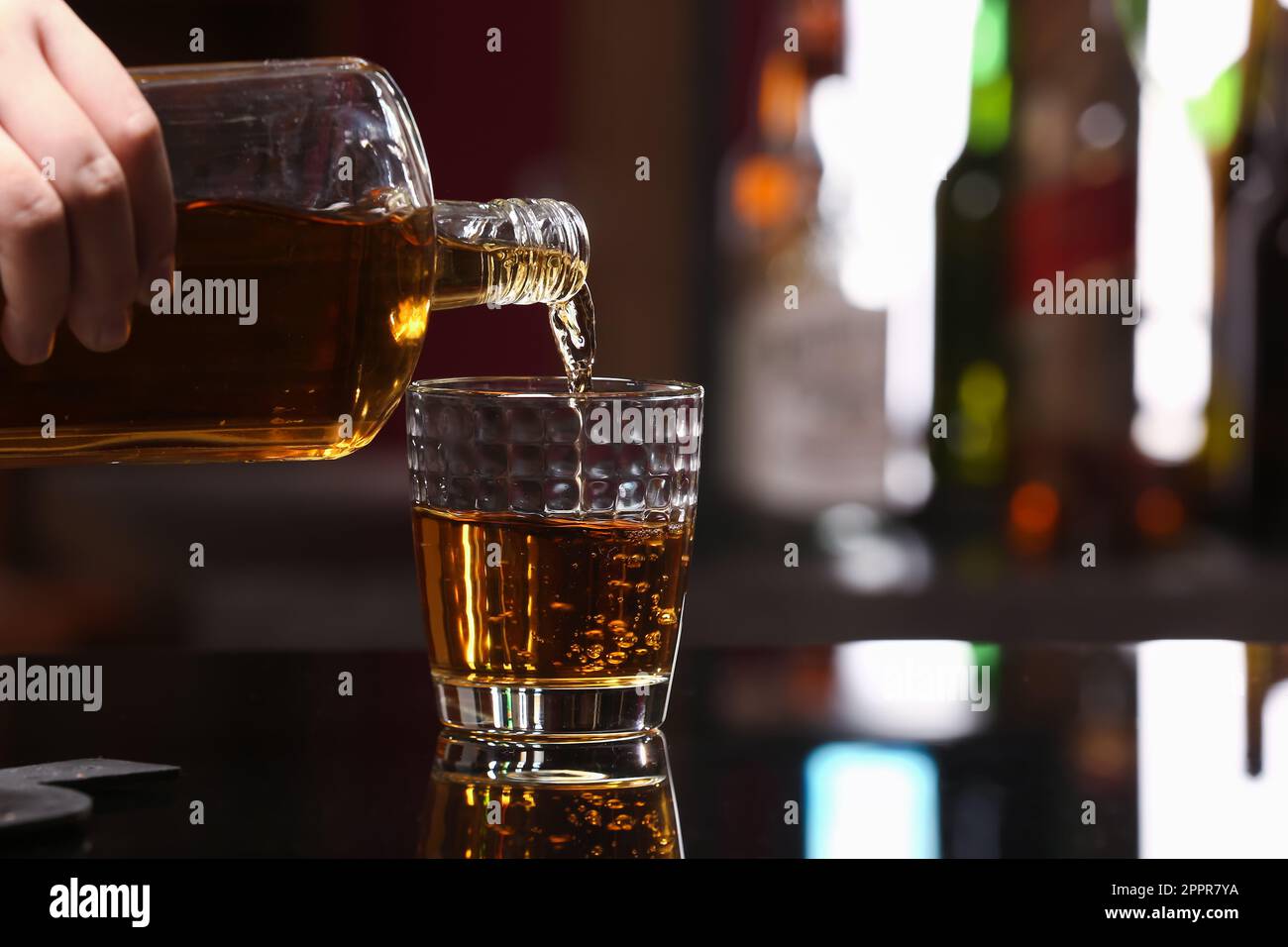 Woman pouring tasty rum from bottle into glass at table in bar Stock ...