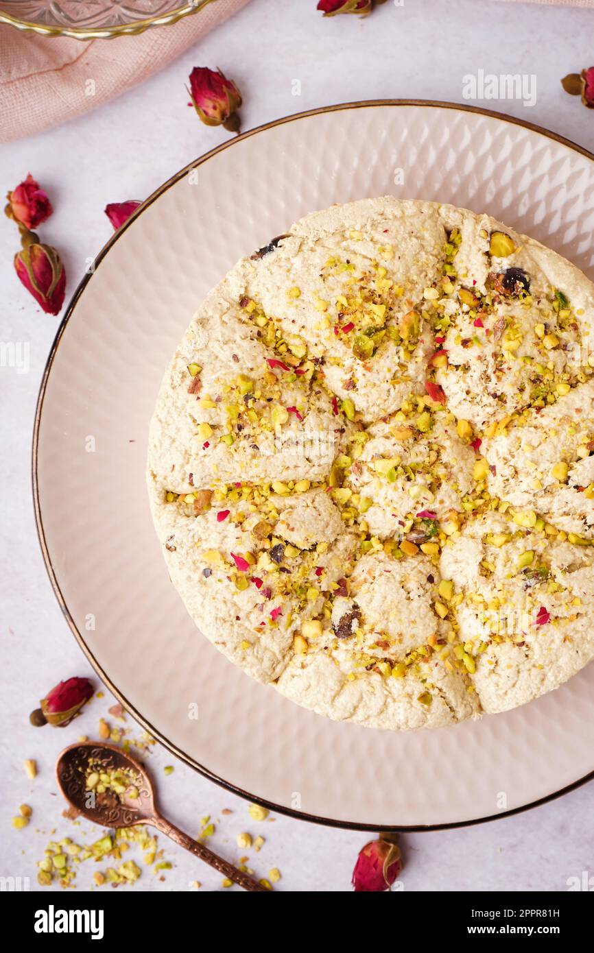 Plate of tasty Tahini halva with pistachios on light background Stock ...