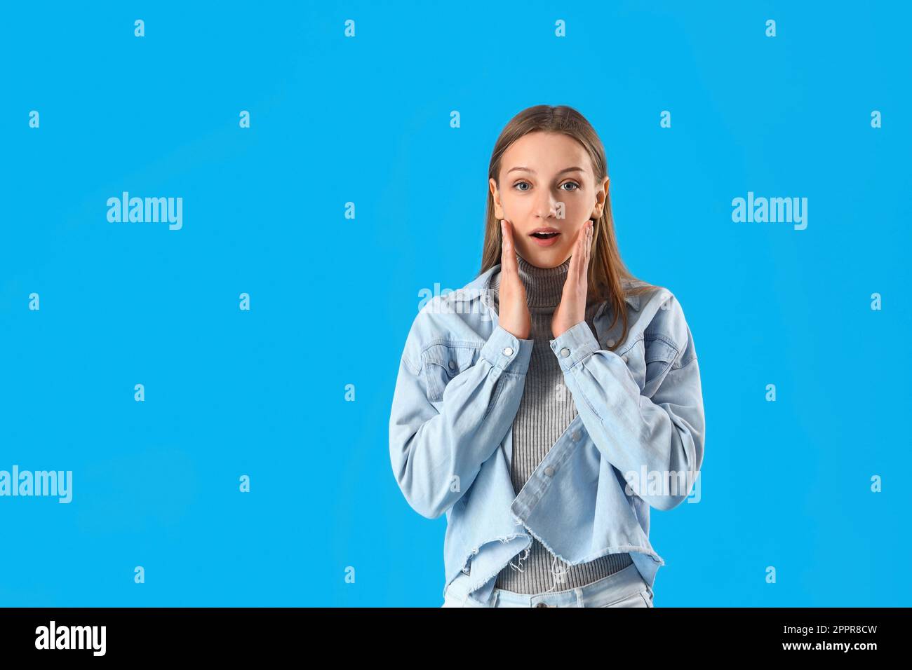 Shocked female student on blue background Stock Photo - Alamy