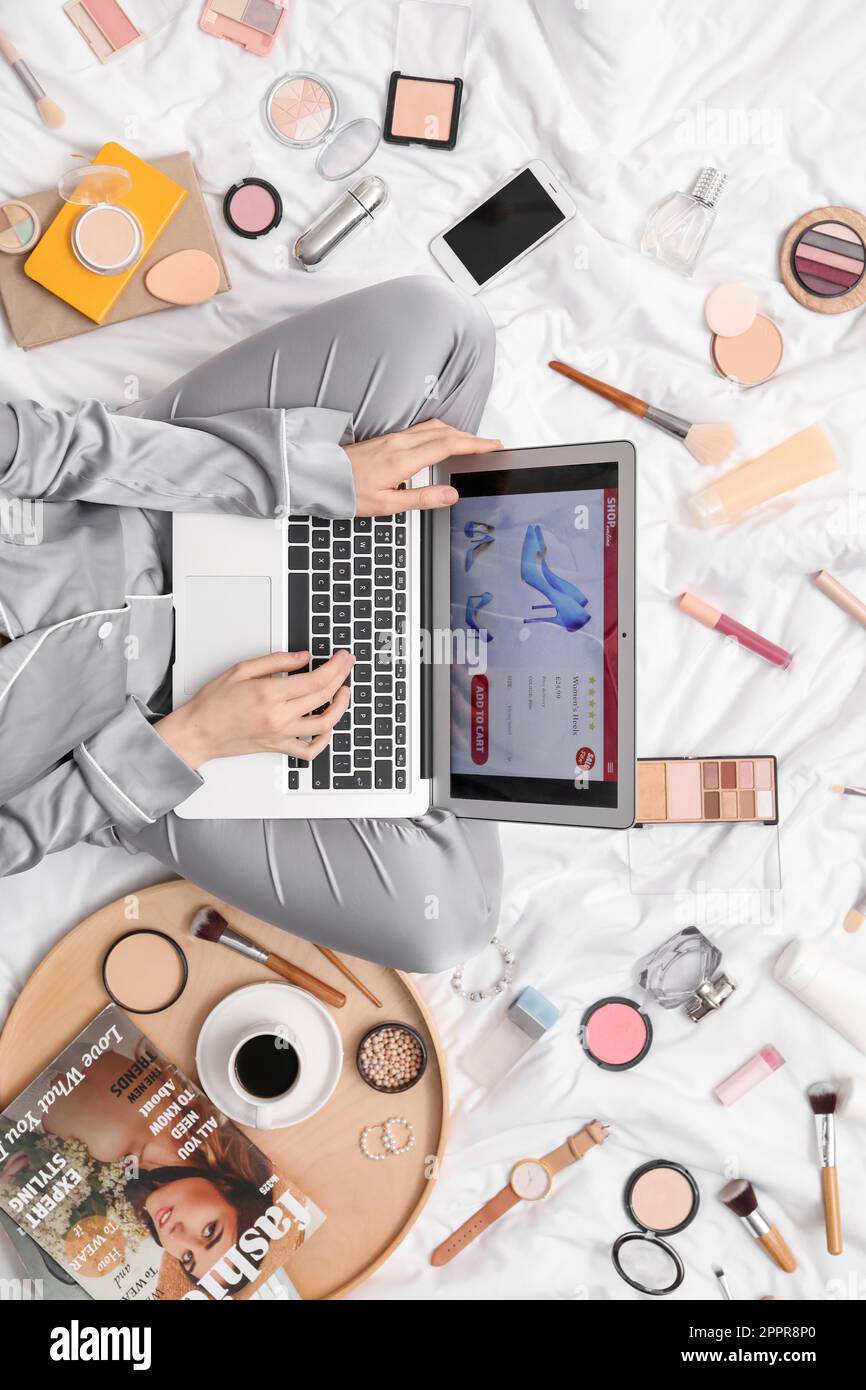 Woman with laptop, makeup products and accessories shopping online on ...