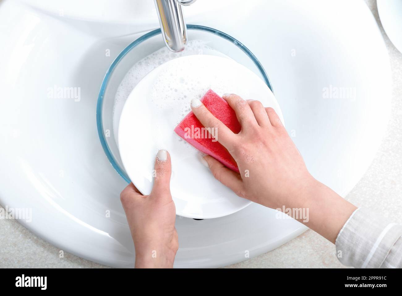 Woman washing plate with sponge in sink, closeup Stock Photo - Alamy