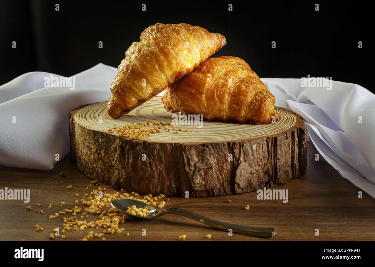 Delicious croissants on wooden trunk, with white towel around, seed ...