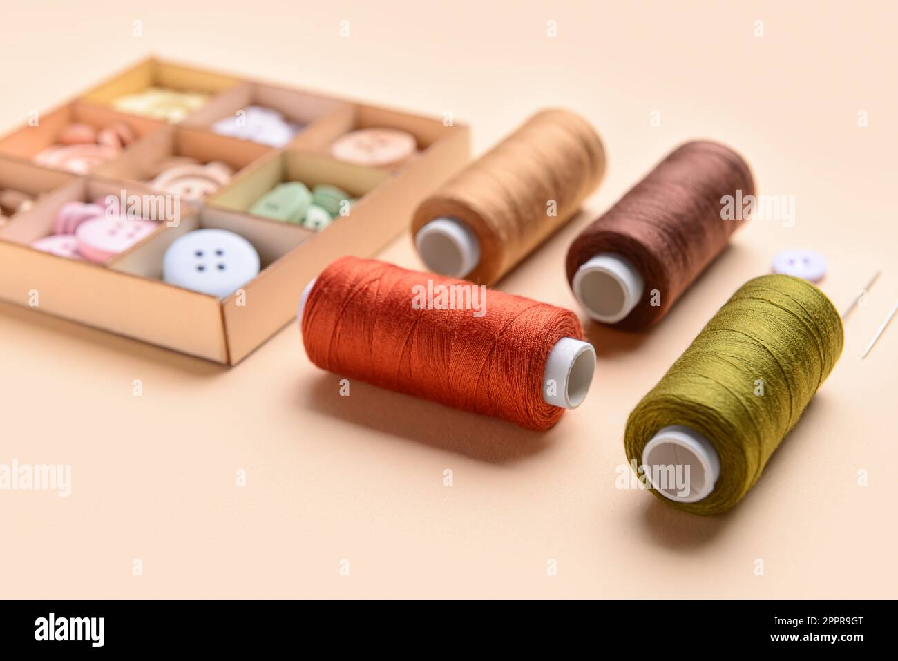 Set of thread spools and buttons on color background, closeup Stock ...