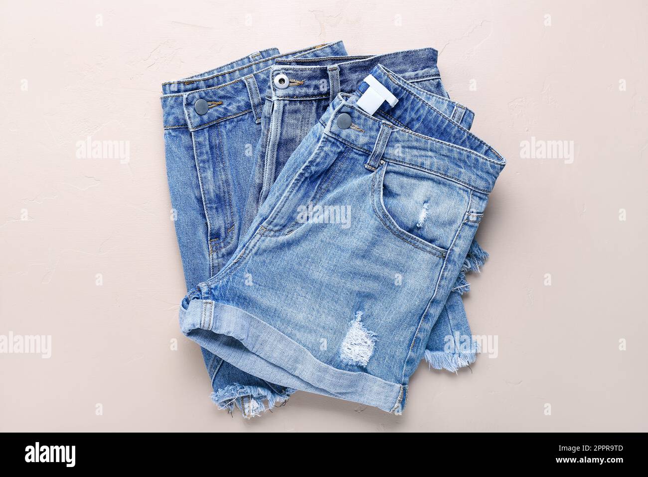 Stylish denim shorts on beige background Stock Photo - Alamy