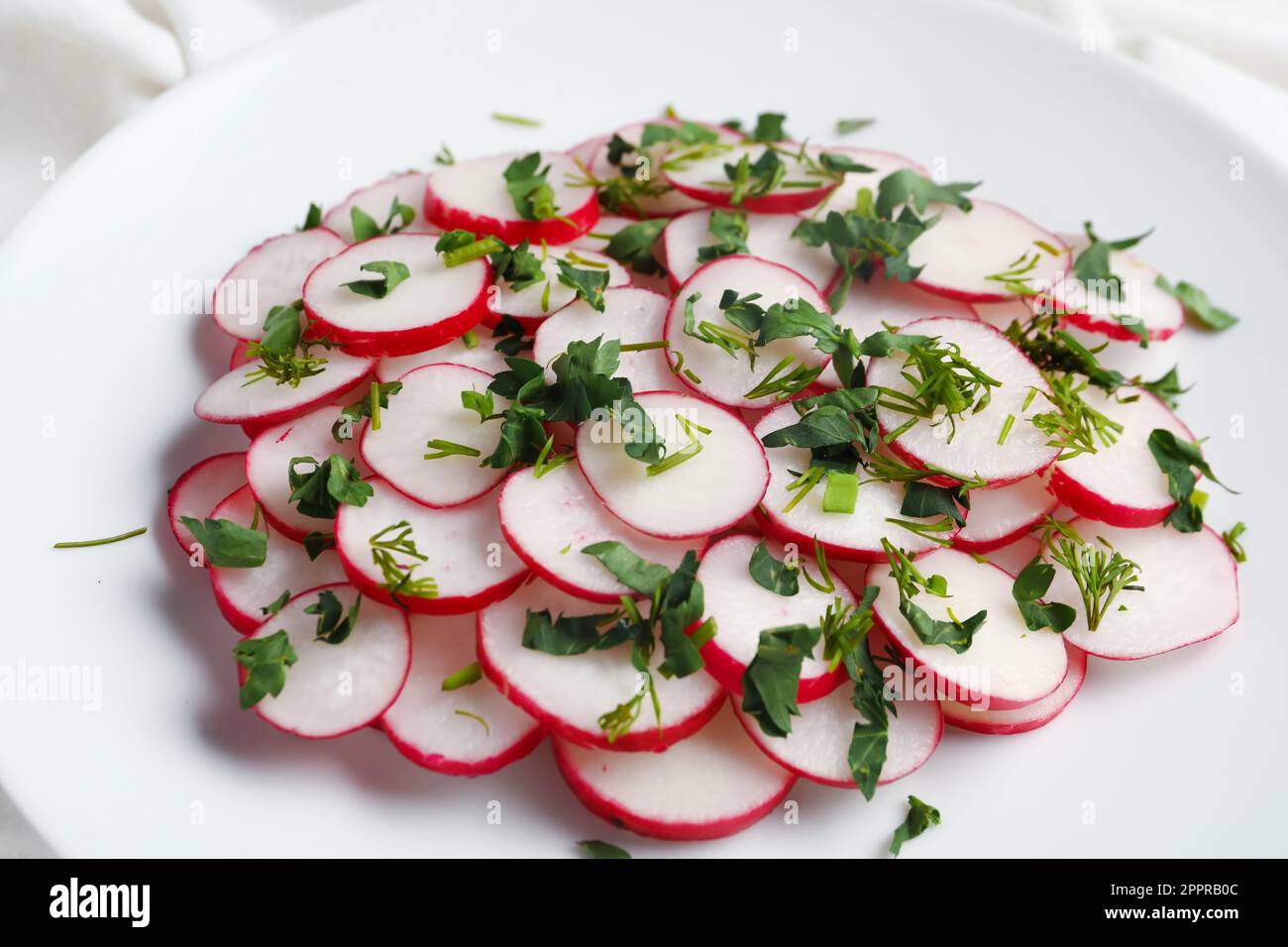 Plate with fresh slices of radish on white background Stock Photo - Alamy