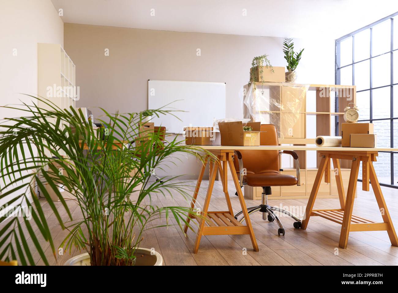 Workplace with cardboard boxes in office on moving day Stock Photo - Alamy
