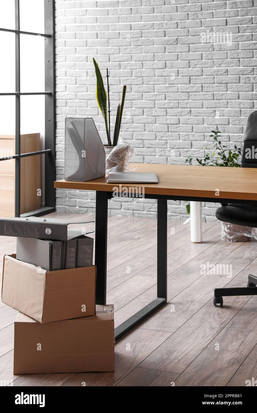 Workplace with cardboard boxes in office on moving day Stock Photo - Alamy
