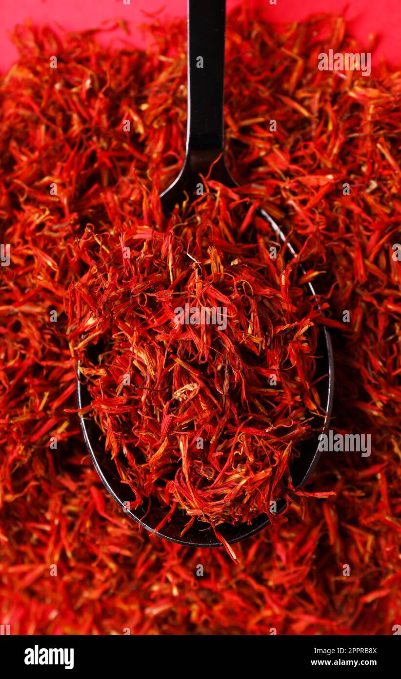 Spoon with pile of saffron as background, closeup Stock Photo - Alamy