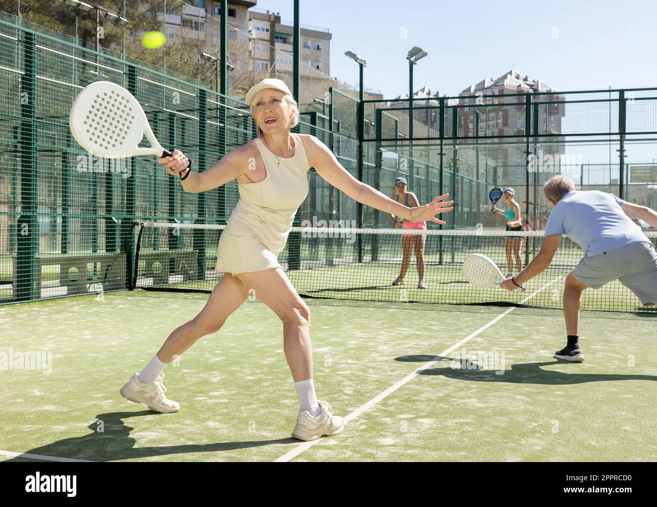 Mature sporty woman playing padel game in court on sunny day Stock ...