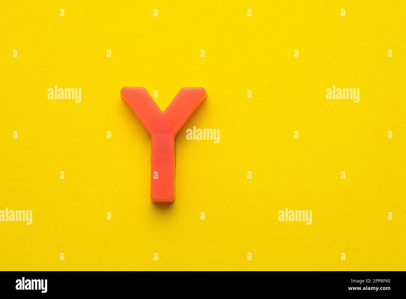 Alphabet letter Y - Peach colored plastic piece on yellow foamy ...