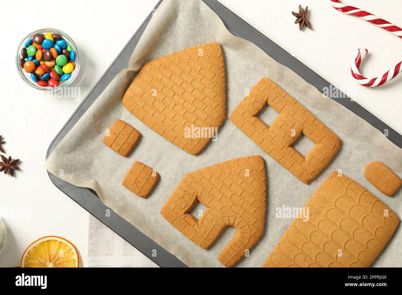 Parts of gingerbread house and ingredients on white table, flat lay ...