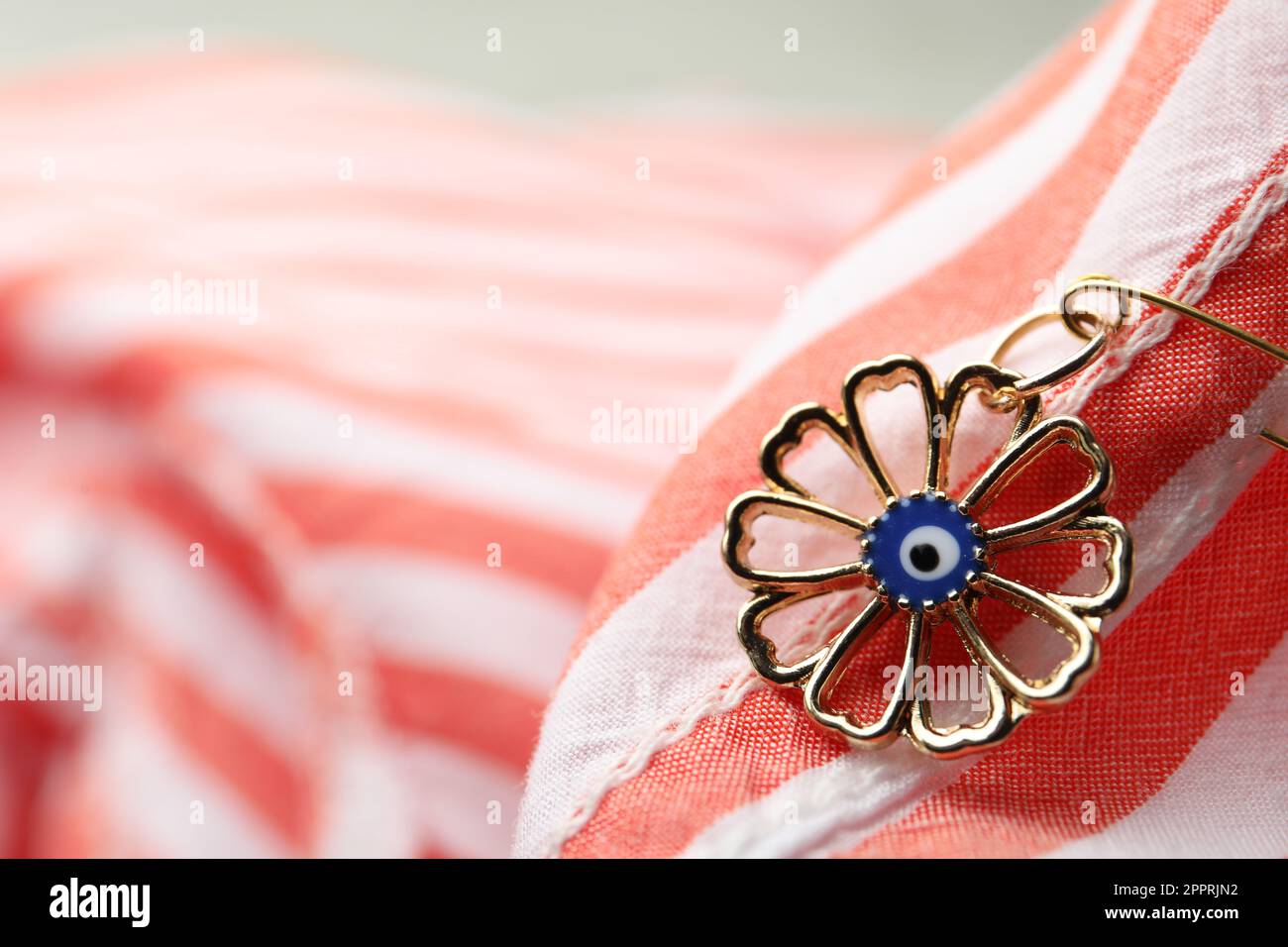 Evil eye safety pin on clothing, closeup Stock Photo - Alamy