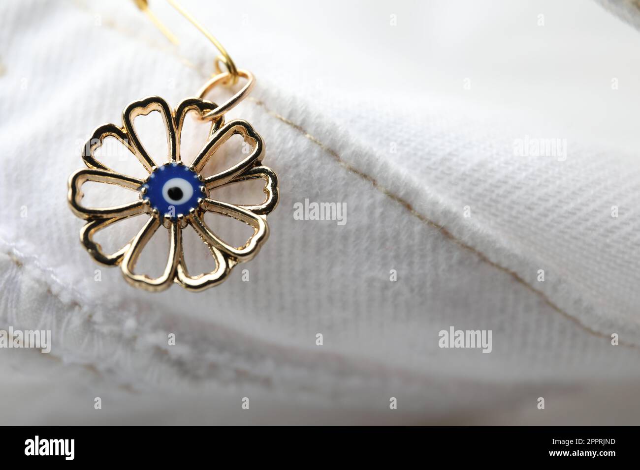 Evil eye safety pin on clothing, closeup Stock Photo - Alamy