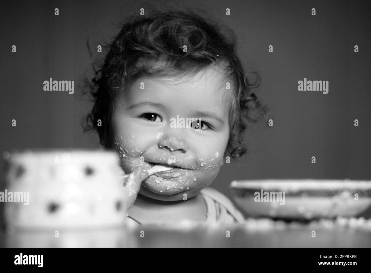 Cute little baby is being fed using spoon. Little child eating fruit ...