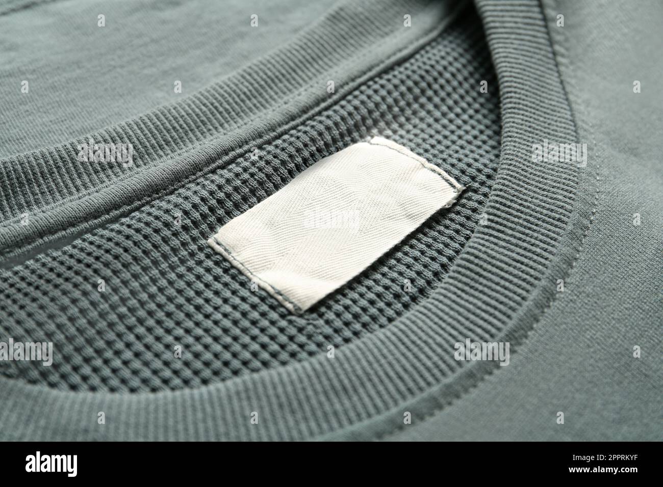 Blank clothing label on grey sweater, closeup Stock Photo - Alamy