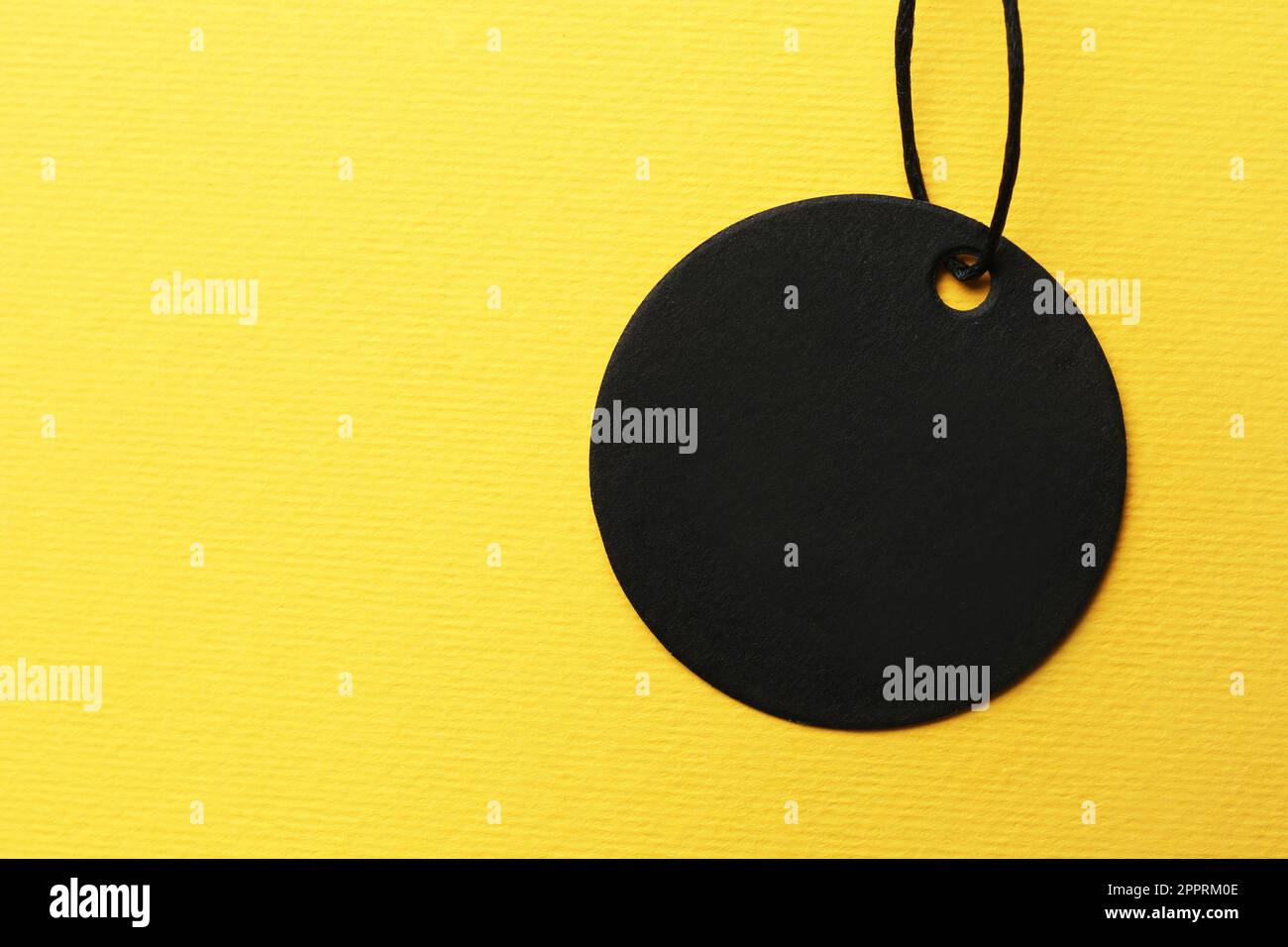 Circle shaped tag with space for text on yellow background, top view ...