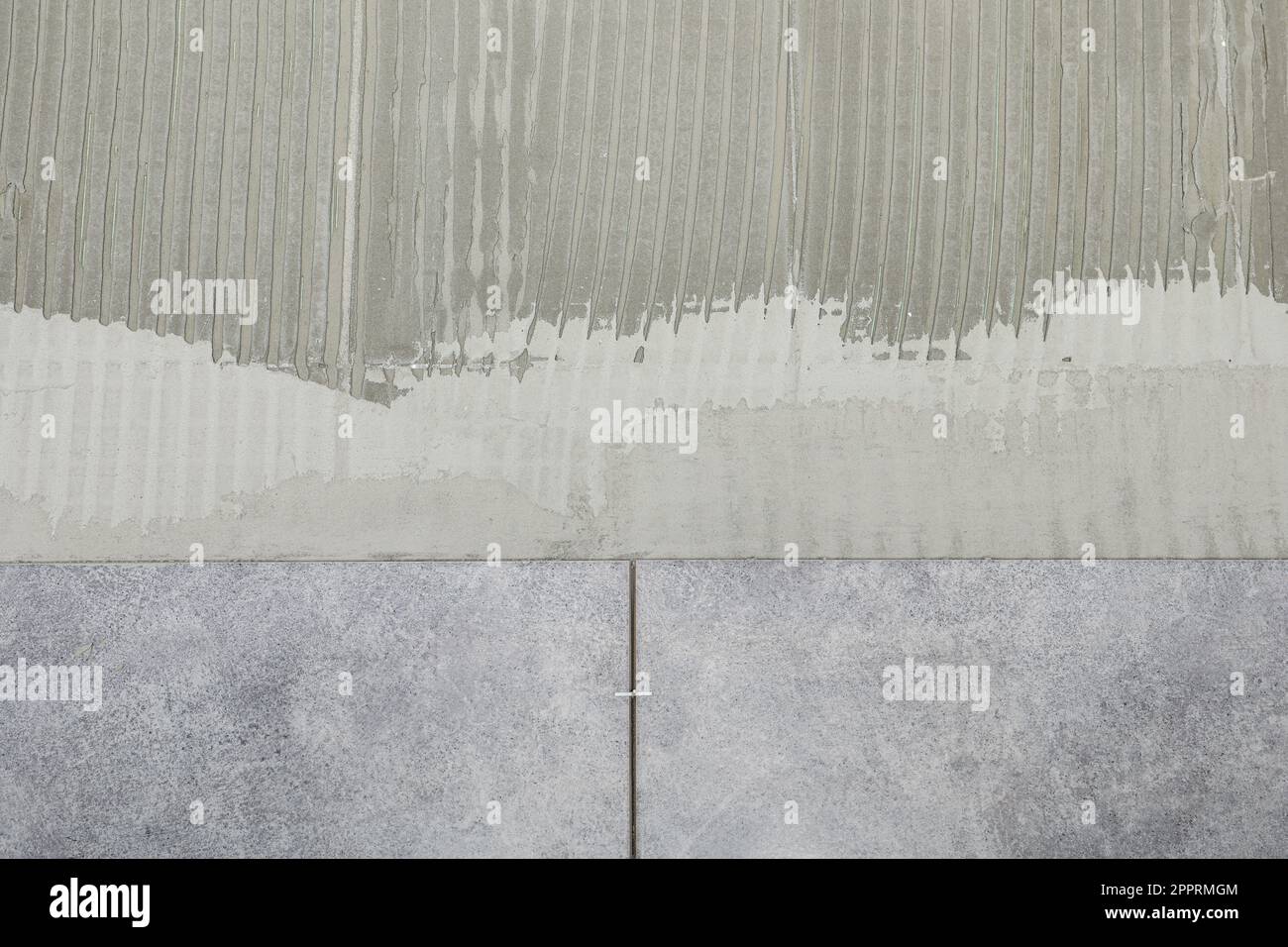 Adhesive mix and ceramic tiles on wall, closeup Stock Photo - Alamy