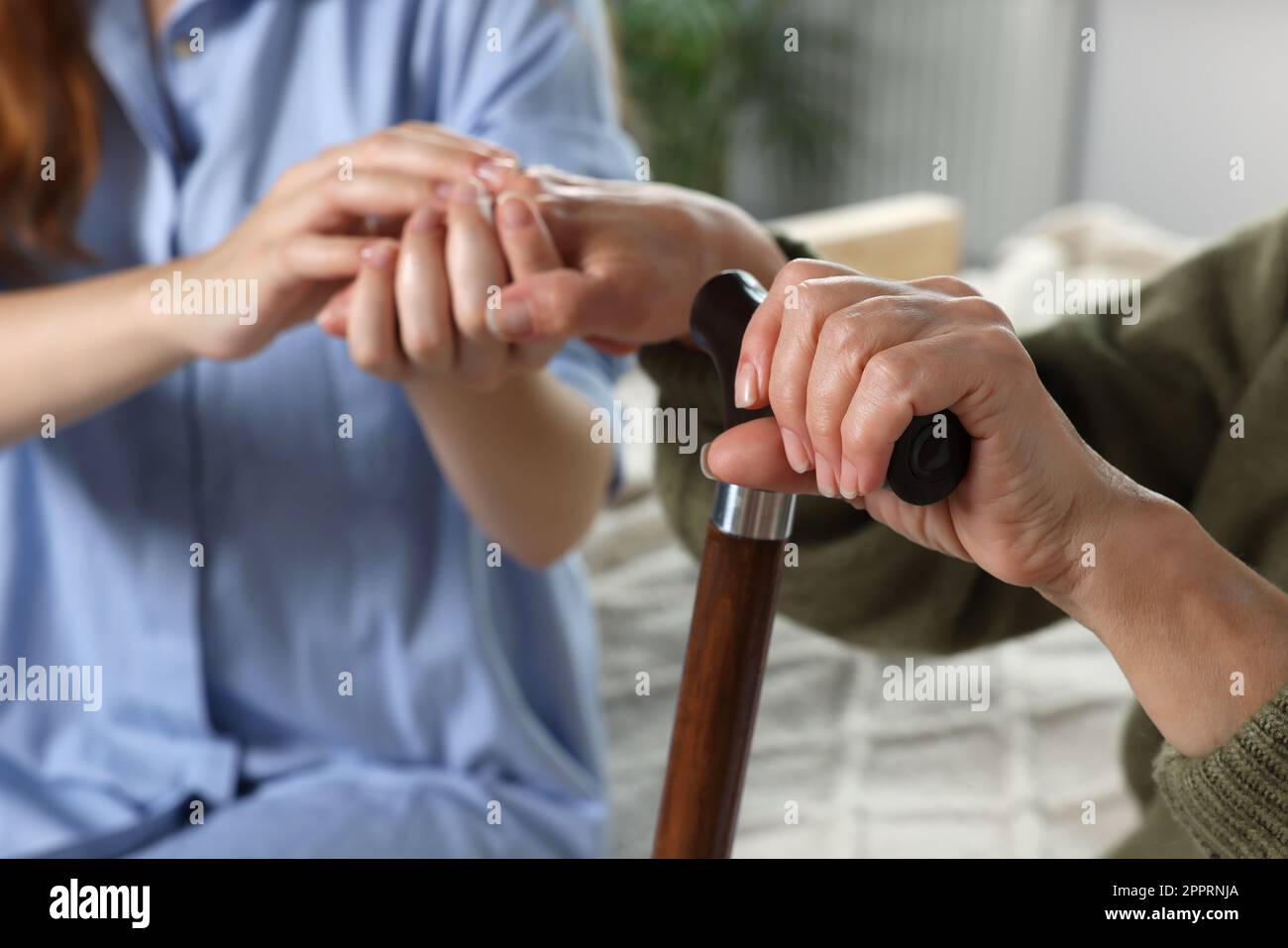 Caregiver and elderly woman with walking cane at home, closeup Stock ...