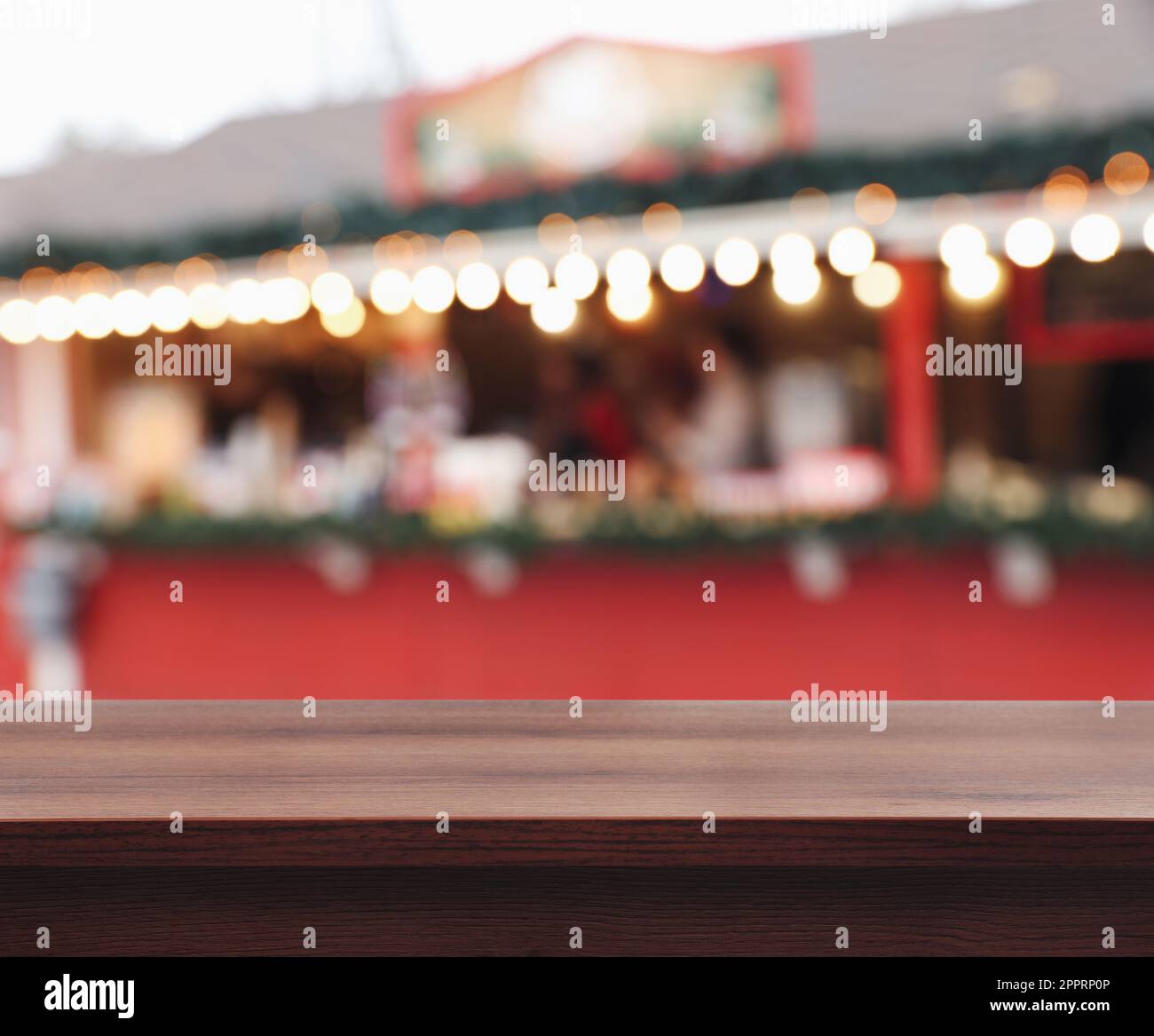 Empty wooden surface and blurred view of Christmas fair stall outdoors ...