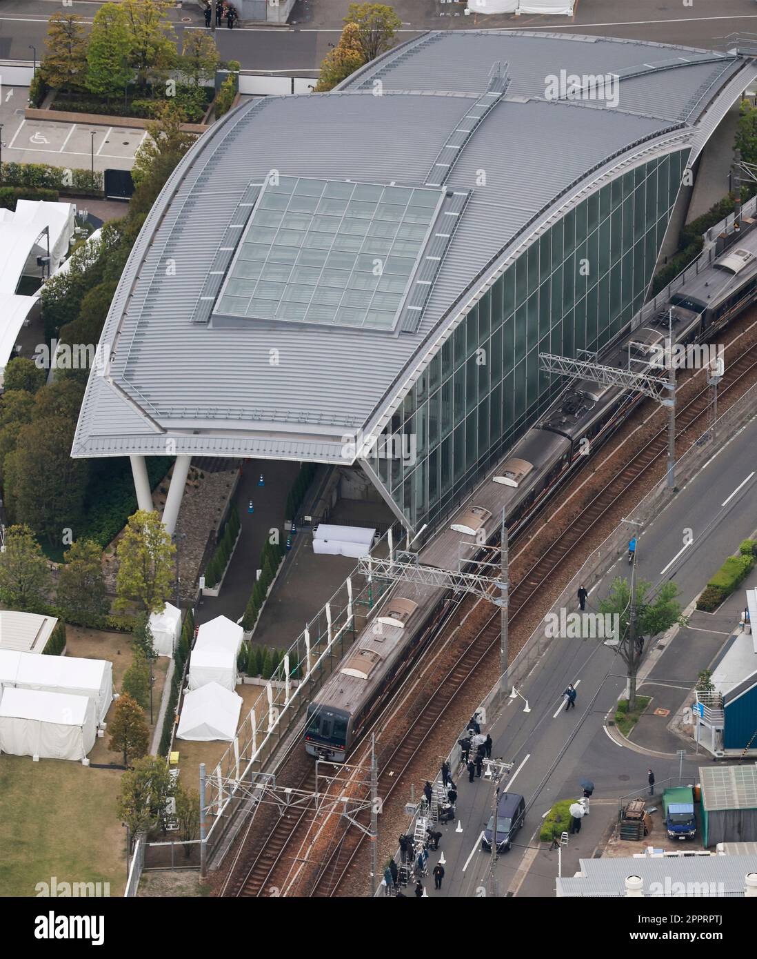 A train passes near the site of the derailment accident in Amagasaki City, Hyogo Prefecture on ...