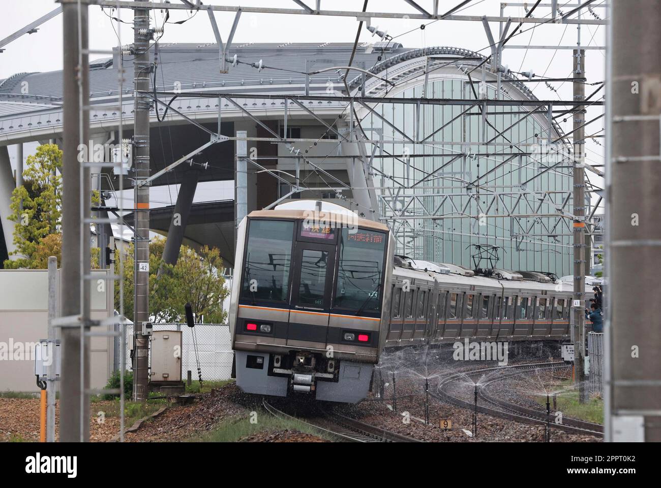 A train passes near the site of the derailment accident in Amagasaki City, Hyogo Prefecture on ...