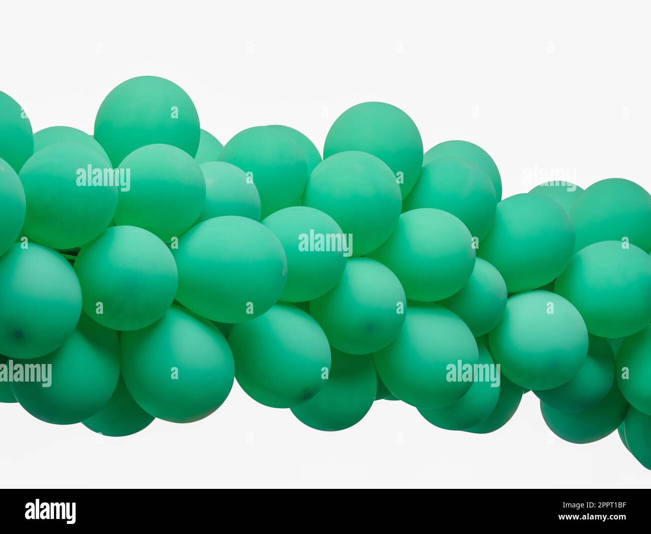 Green color decorated balloons in a row over white background , with ...