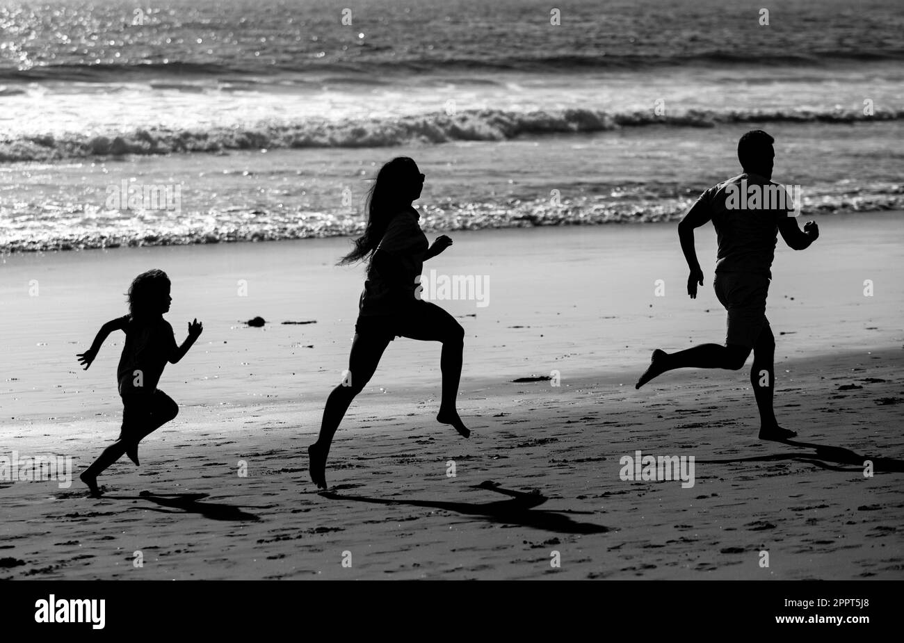 Fitness family running on a sandy beach. Sporty family father, mother ...