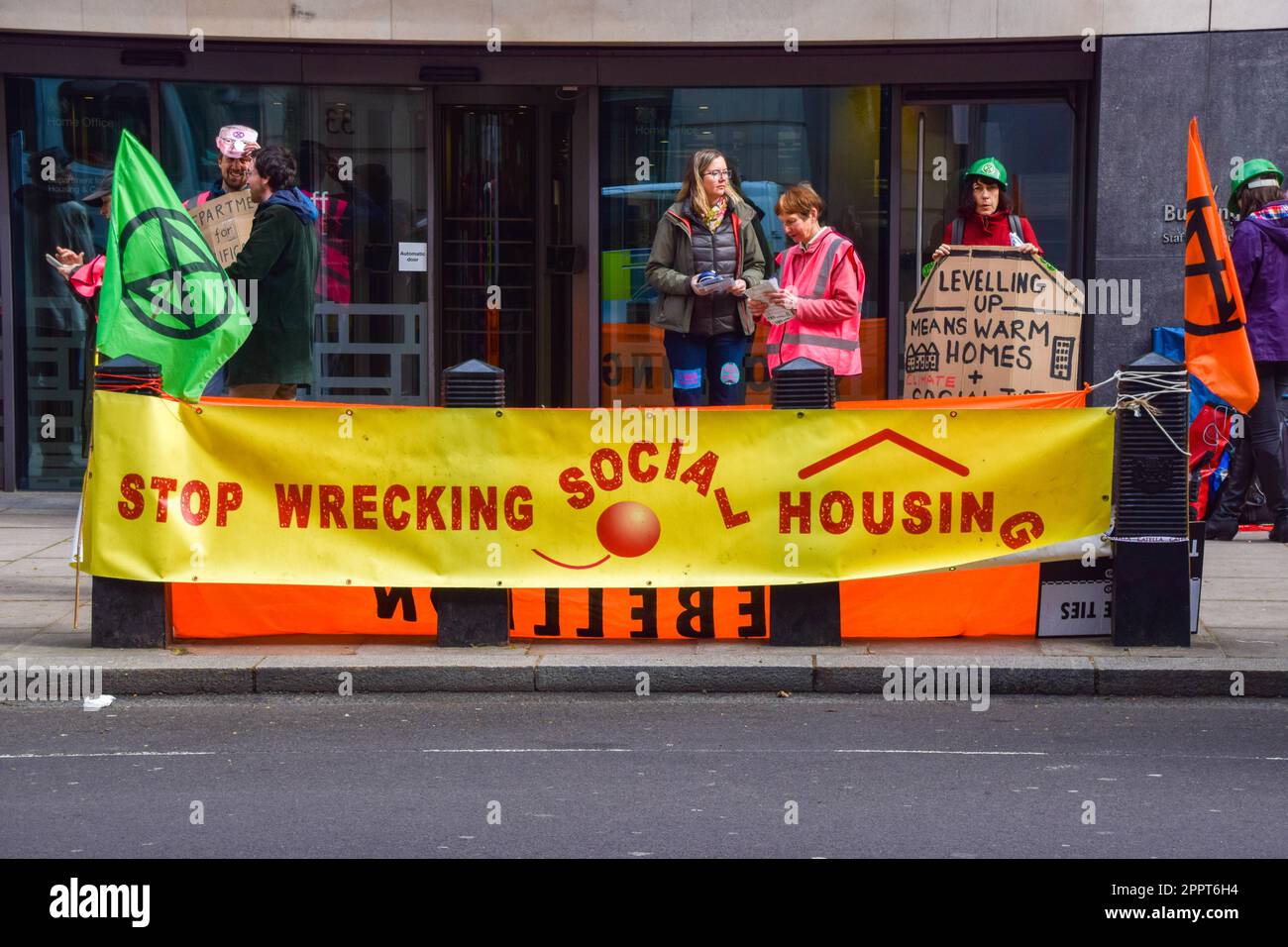 London, UK. 24th Apr, 2023. Protesters stand behind a banner which ...