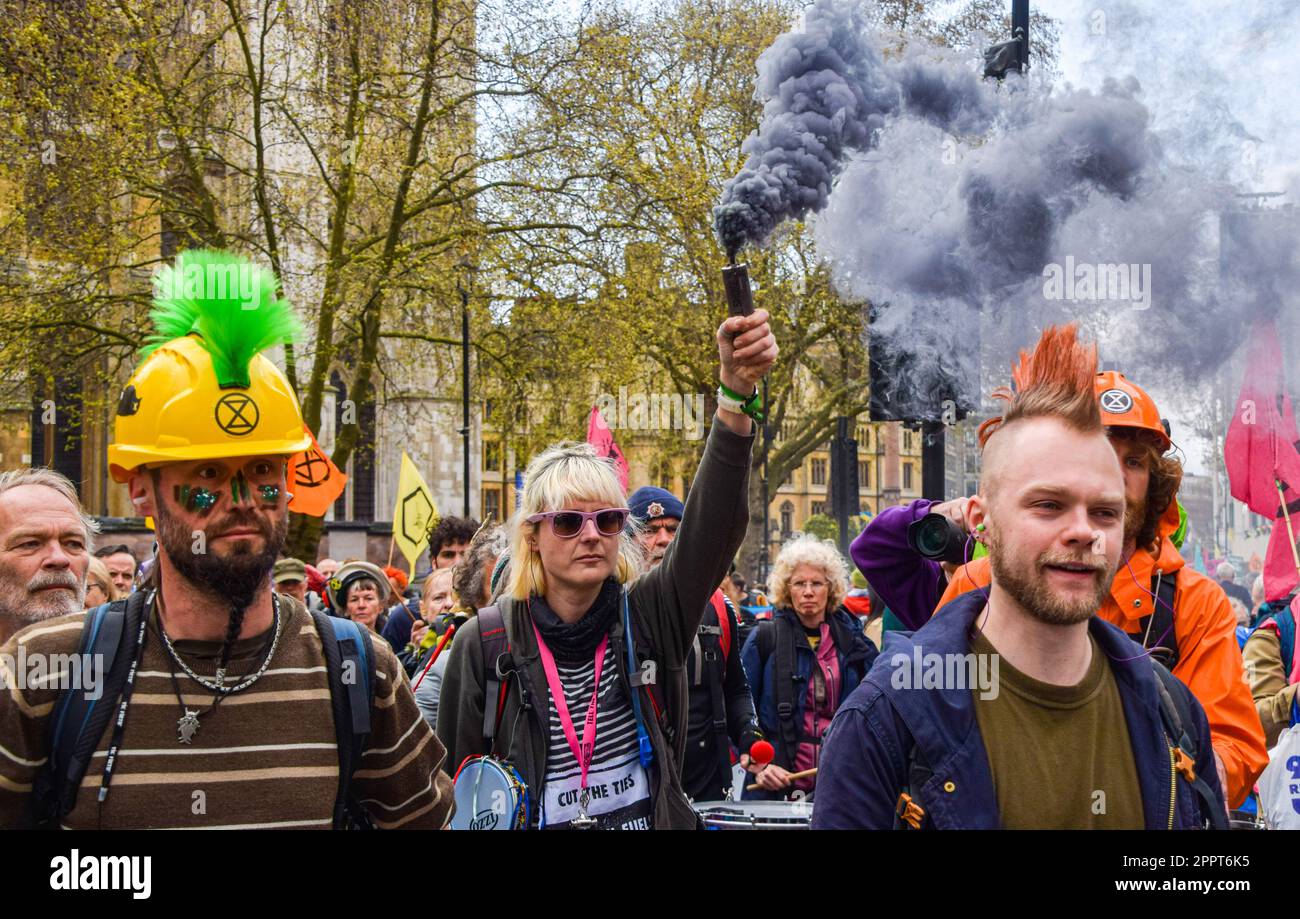 London, UK. 24th Apr, 2023. A protester holds a smoke flare in ...