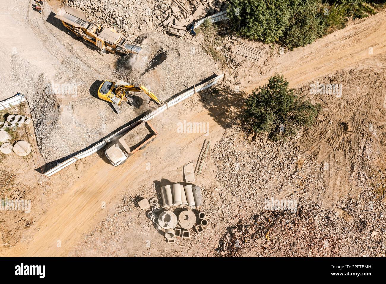 excavator loading crushing stone into a dump truck. aerial top view of construction site Stock ...