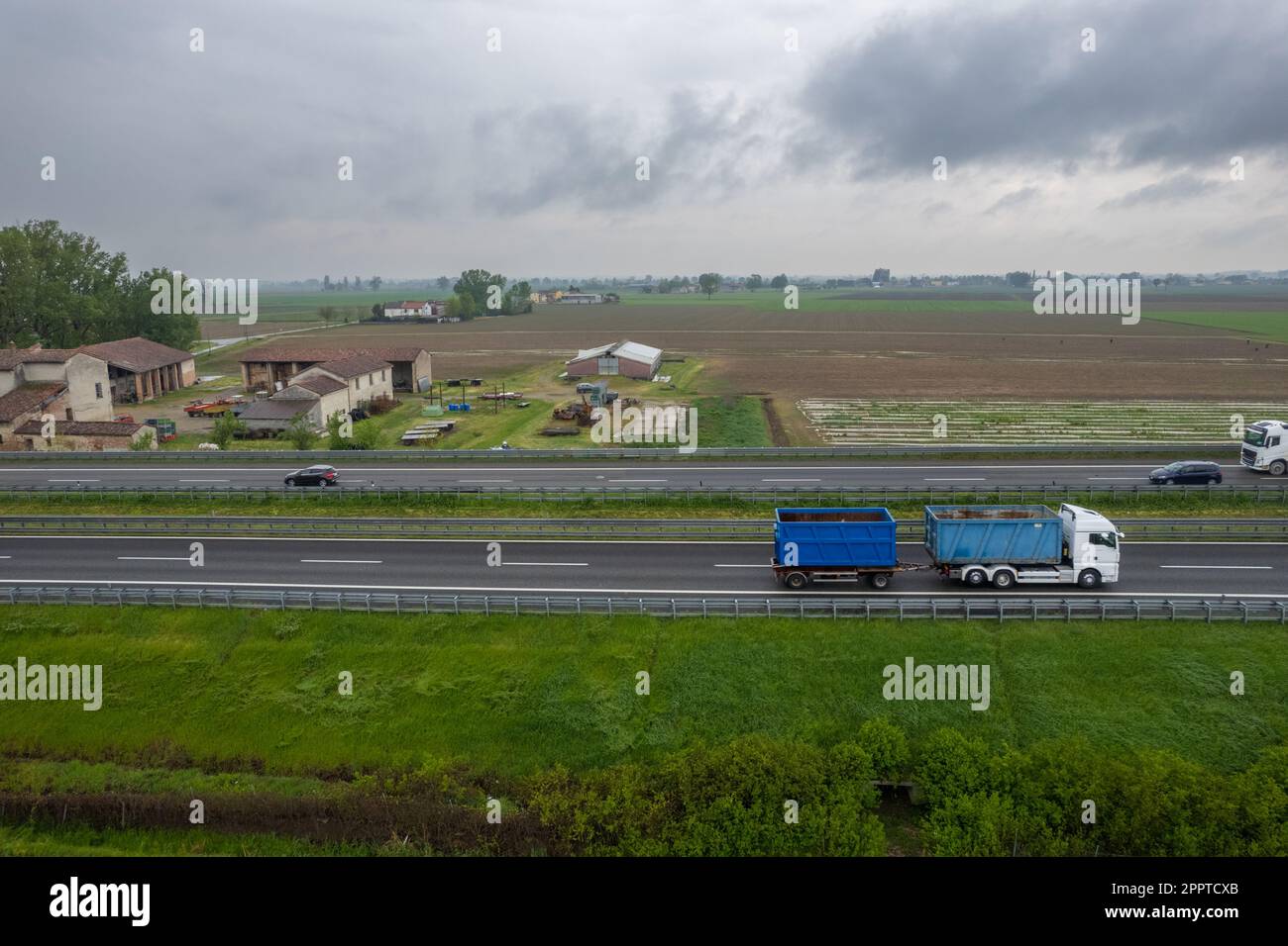 Piacenza, Italy - April 2023 Cargo trucks and cars in the motorway a1 ...