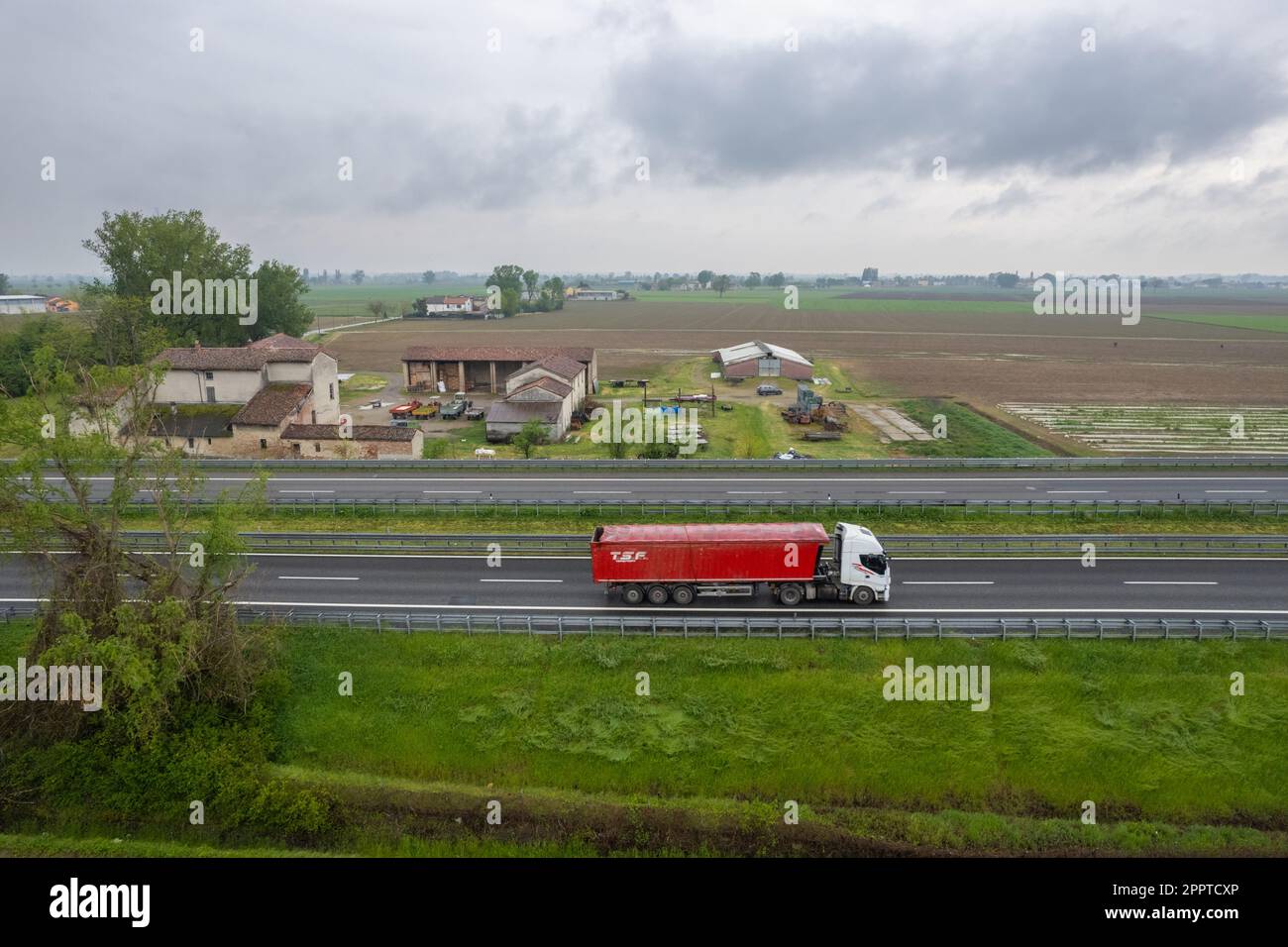 Piacenza, Italy - April 2023 Cargo trucks and cars in the motorway a1 ...