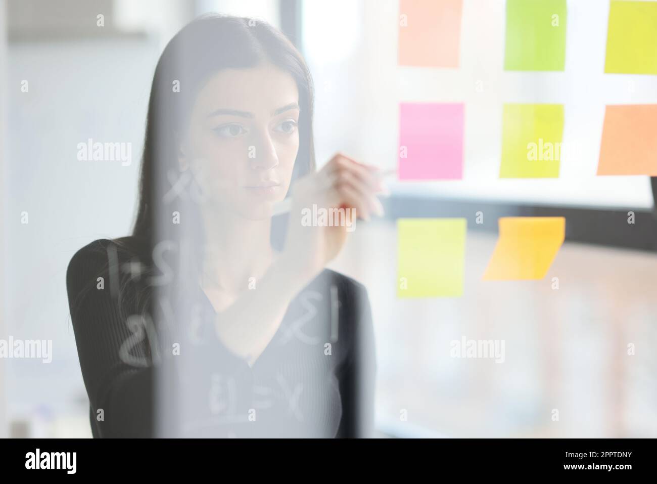 Woman creates business plan putting sticky notes on wall Stock Photo ...
