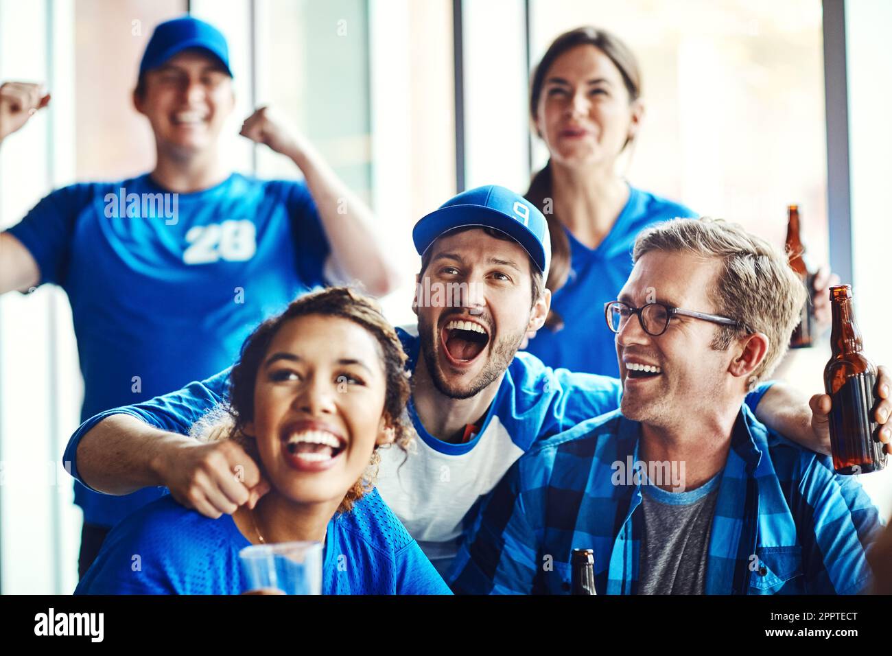 On game day, we wear blue. A group of excited friends cheering on their ...