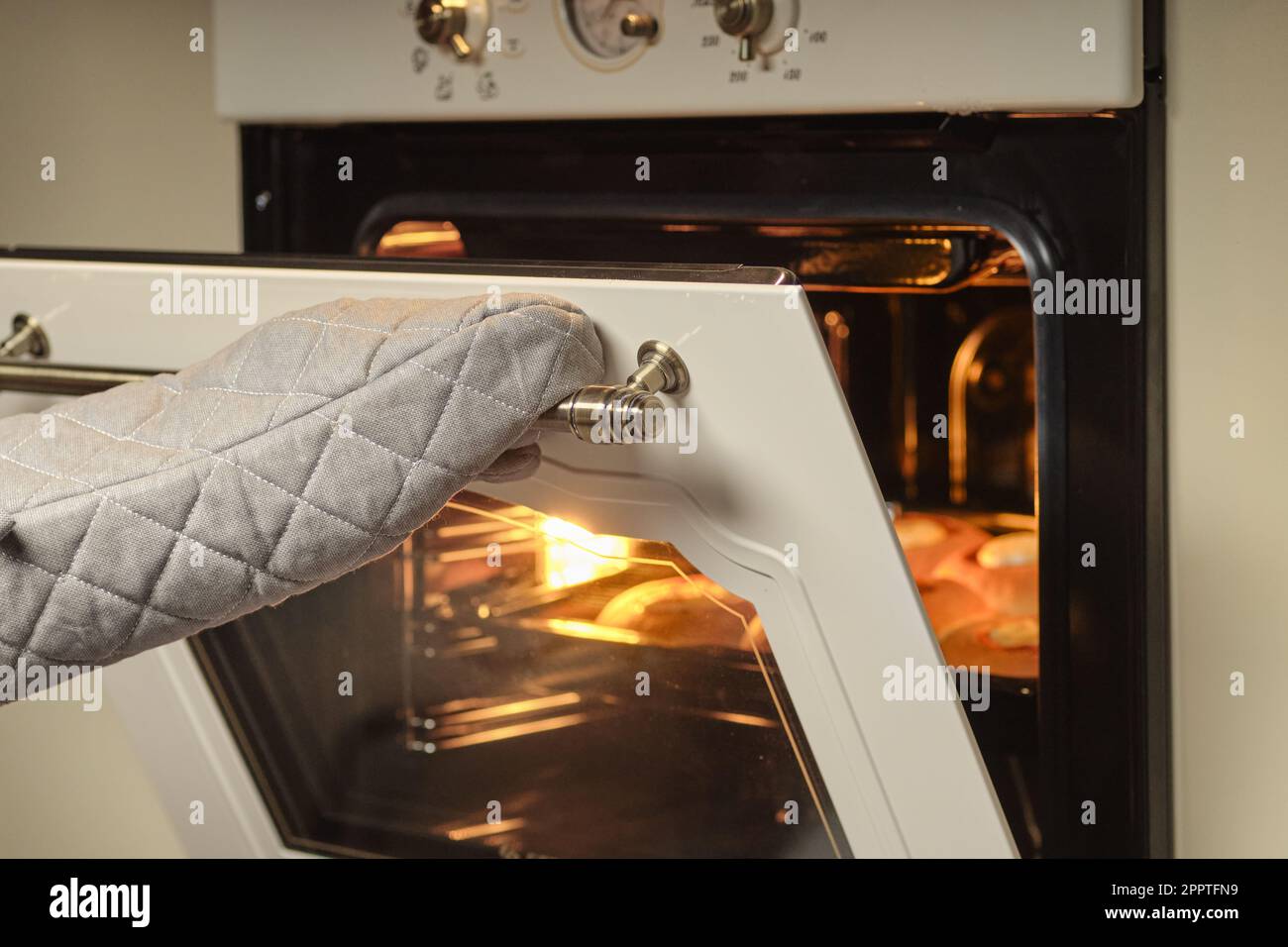 Female hands in mittens open oven door to check the bakery products Stock Photo - Alamy